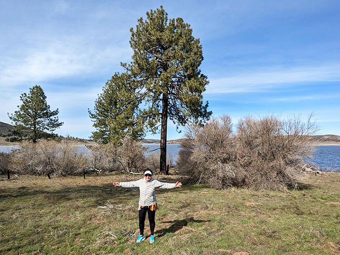 An unexpected oasis amid arid lands, where a visitor celebrates the discovery of water and greenery in this surprising desert landscape.
