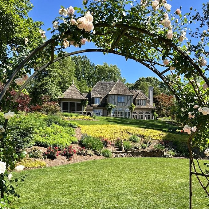 A rose-covered arbor frames the Manor House like nature's version of the perfect Instagram filter. Jane Austen would approve.