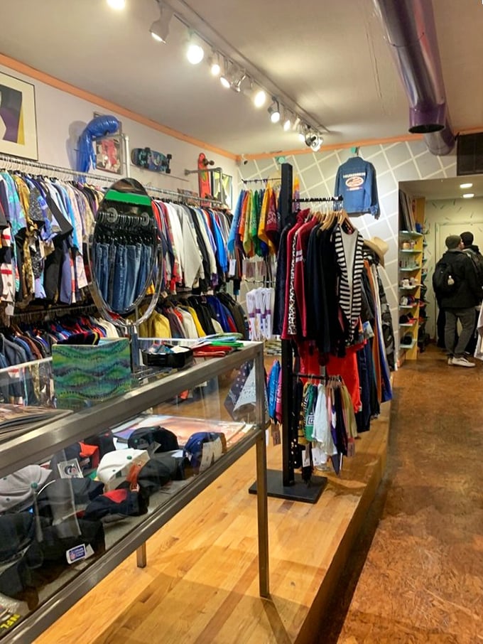 Treasure hunters navigate racks of vintage finds. The wooden floors have supported decades of fashion seekers looking for that perfect piece of nostalgia.