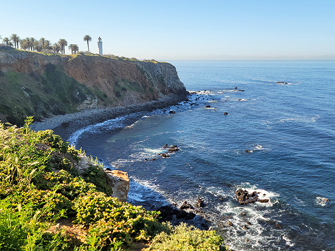 The view that makes you forget your phone password&mdash;crystalline waters meeting golden cliffs with the lighthouse standing watch in the distance.