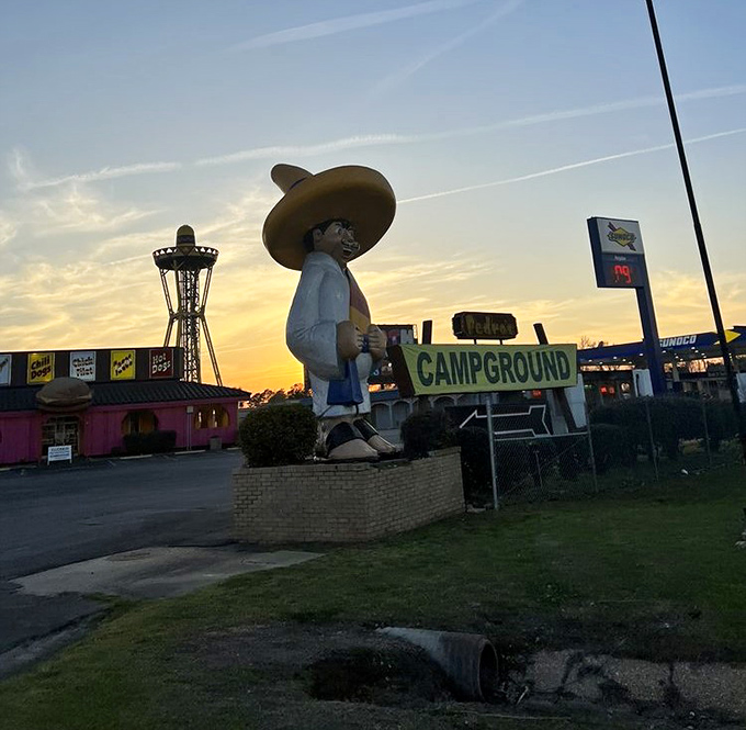 Even at sunset, the giant sombrero-wearing mascot keeps watch over the campground. Road-weary travelers find respite in his cartoonish shadow.