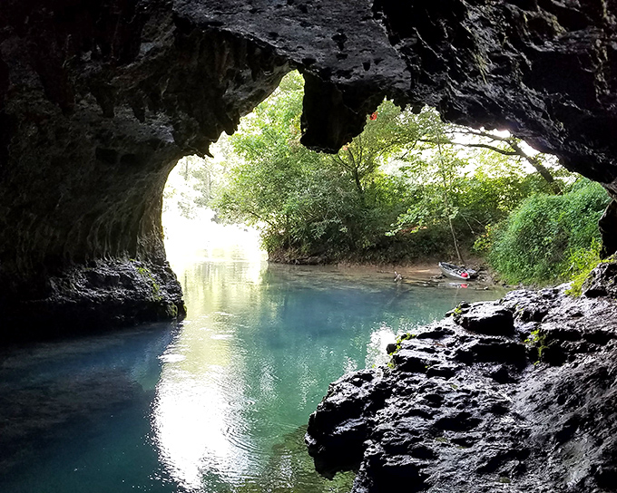 Where sunlight meets mystery. This natural archway at Cave Spring reveals the aquamarine waters connected to Devil's Well through miles of hidden passages.
