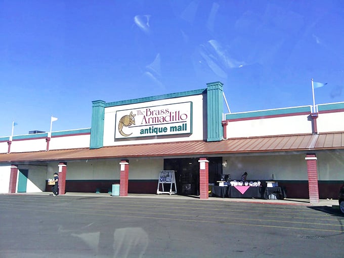 The distinctive teal and copper facade of Brass Armadillo stands like a retro oasis in the desert, promising air-conditioned adventures within.