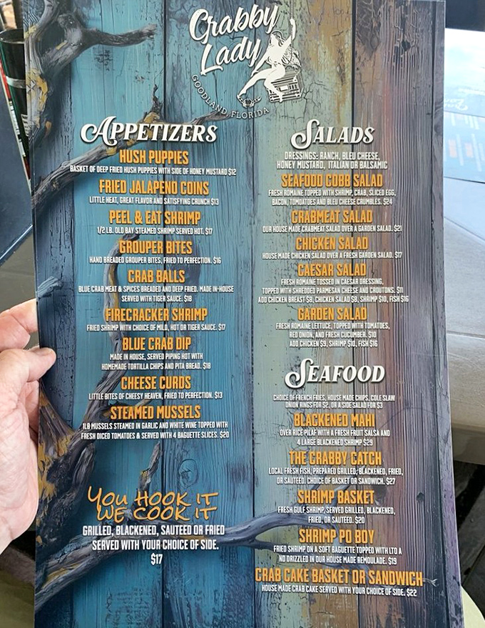 A menu that reads like poetry to seafood lovers. Blue-painted boards showcase treasures from the deep, with "You Hook It" options for ambitious anglers.
