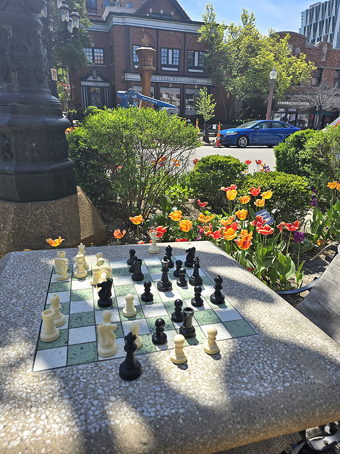 Outdoor chess becomes an art form when your battlefield sits among blooming flowers and city life.
