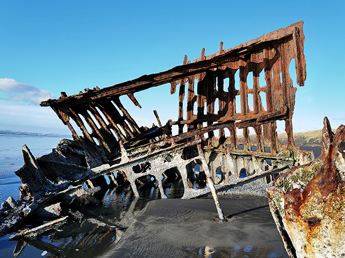 The skeletal ribs of this once-proud sailing vessel reach skyward like rusty fingers, telling tales of stormy nights and fateful decisions.