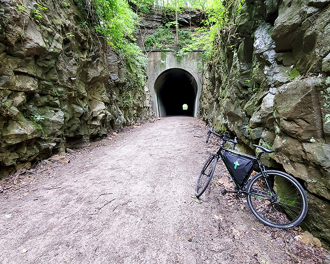 The Tunnel Hill State Trail's namesake passage beckons cyclists into its cool embrace. History and adventure await on the other side.