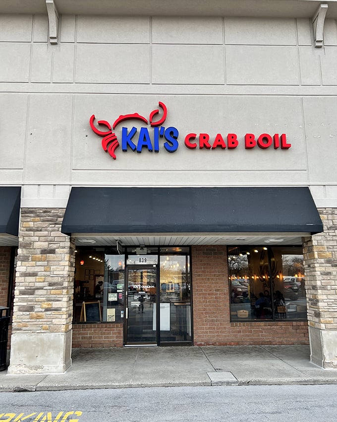 Kai's Crab Boil's bright red crab sign is like a friendly wink in a strip mall—promising messy, delicious seafood adventures within.