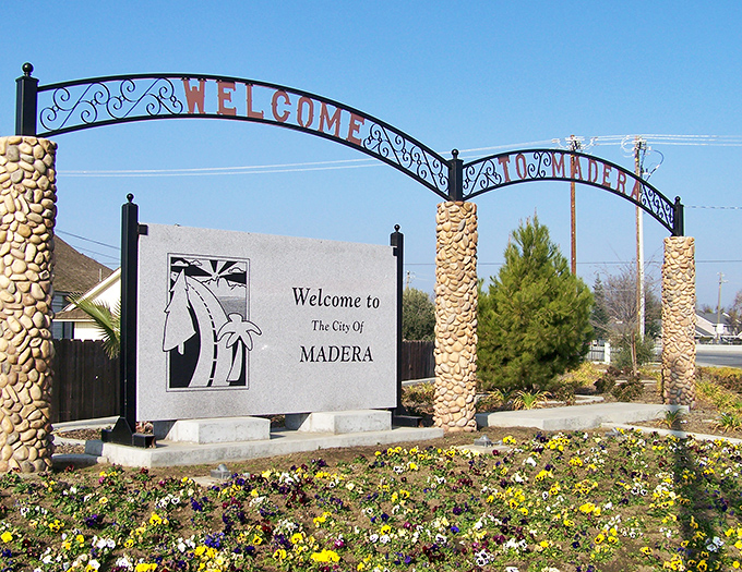 Welcome to Madera! This charming entrance sign greets visitors with colorful flowers. A budget-friendly oasis in California's agricultural heartland.