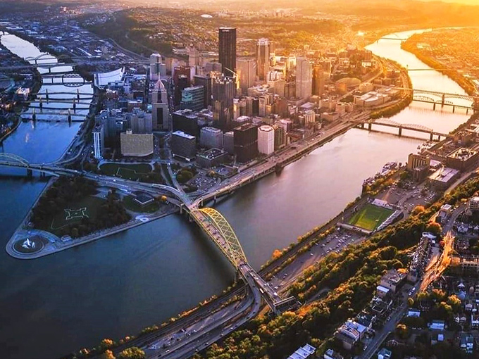 Pittsburgh from above is pure magic! Three rivers embracing a city of bridges and towers bathed in golden sunset light.