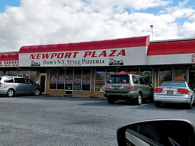 Newport Plaza's pizza treasure. Dom's red and white awning signals you've found the place where folding your slice is practically mandatory.