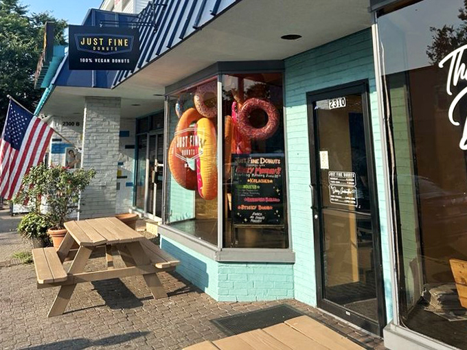 The cheerful exterior of Just Fine Donuts with its picnic table – because some donuts are too good to wait until you get home.