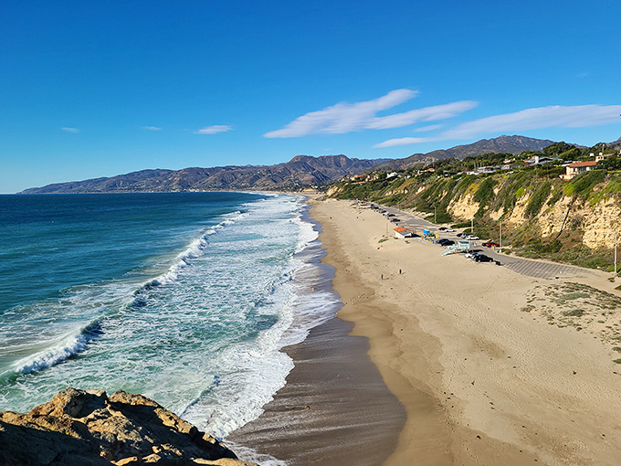 Golden hour at Point Dume beach transforms ordinary sand into a magical canvas, where cliffside climbers appear to defy gravity itself.