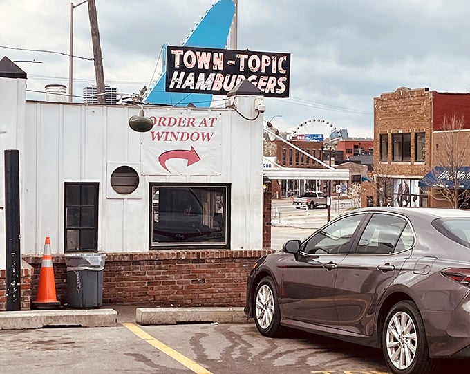 The humble exterior hides a 24-hour burger paradise where strangers become friends over grilled onions and crispy patties.