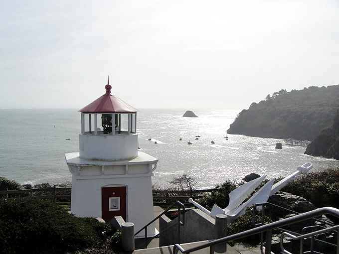 Trinidad: The lighthouse stands guard over a harbor nestled beneath towering cliffs, a scene straight from a maritime painting.