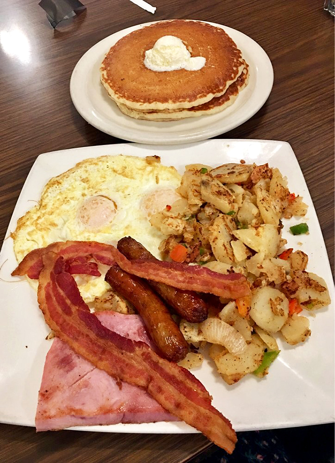 Breakfast nirvana achieved: perfectly cooked eggs, crispy bacon, sausage links, and home fries that make you question every other potato you've ever eaten.