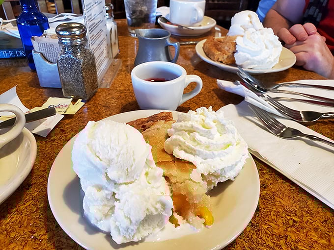 Apple pie that doesn't just whisper "homemade"—it practically shouts it with mountains of whipped cream that would make your grandmother both jealous and proud.