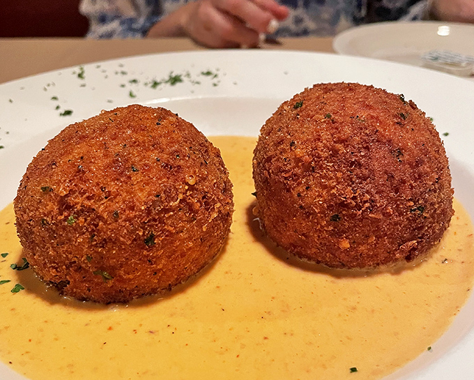 These golden arancini spheres aren't just rice balls &ndash; they're crispy time machines transporting you straight to a Sicilian grandmother's kitchen.