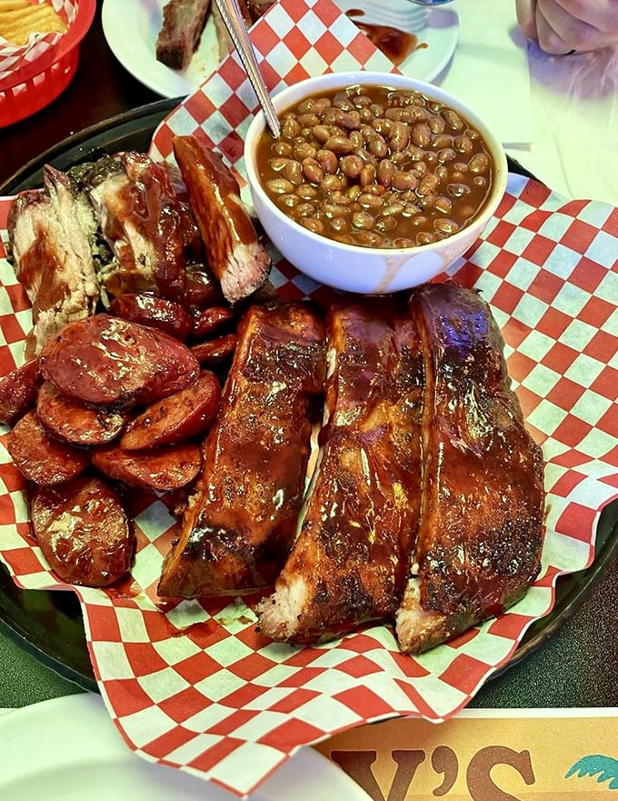 These glistening ribs with a side of baked beans aren't just food&mdash;they're edible proof that patience and smoke create magic.