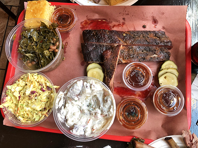 Behold the holy trinity of barbecue: perfectly smoked ribs with that pink ring, collard greens that mean business, and slaw for balance.