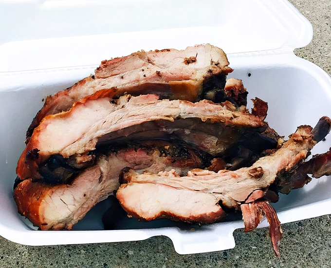 These ribs don't just fall off the bone – they practically leap into your mouth with a perfect pink smoke ring that whispers, "I've been waiting for you."