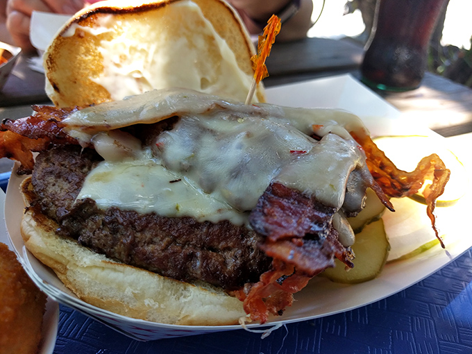 This isn't just a bacon cheeseburger; it's a masterpiece of melted cheese cascading over beef and bacon like a dairy waterfall of dreams.