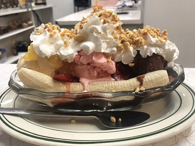 Behold the banana split that laughs in the face of moderation! This isn't dessert, it's an architectural achievement with whipped cream buttresses.
