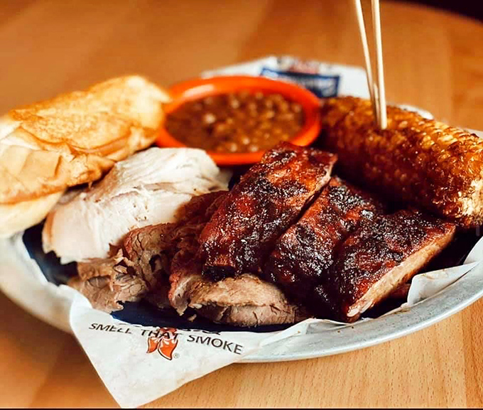 Behold the holy trinity of barbecue &ndash; perfectly sliced brisket, pulled pork, and ribs &ndash; served with the reverence they deserve on paper that proudly proclaims "SMELL THAT SMOKE."