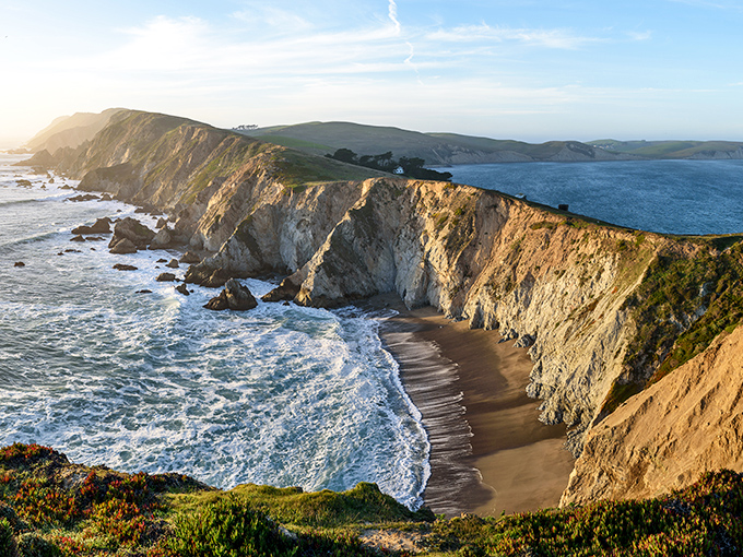 Nature's grand canvas unfolds at Point Reyes' dramatic coastline, where golden cliffs plunge into azure waters like California showing off for company.