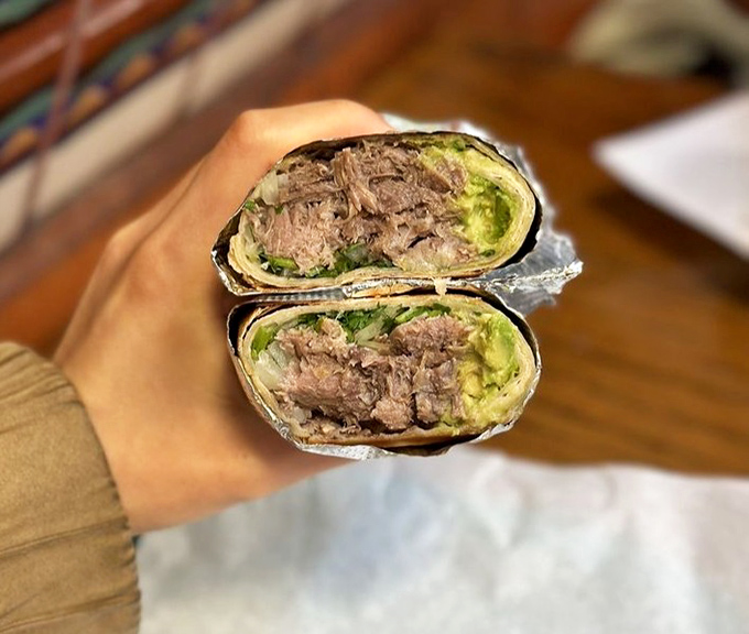 Cross-section perfection! This beef tongue burrito reveals the secret to La Taqueria's fame&mdash;no rice filler, just pure meat-to-avocado harmony wrapped in foil.