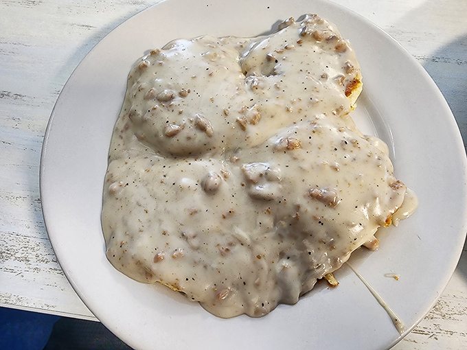 Behold the holy grail of breakfast: biscuits completely submerged in peppery sausage gravy. Architecture this impressive usually requires building permits.