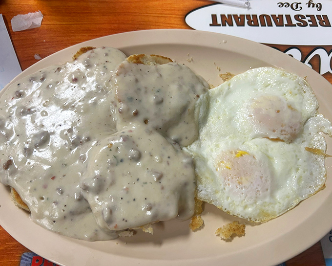 Behold the holy grail of Southern breakfast: fluffy biscuits drowning in creamy sausage gravy that defies gravity.