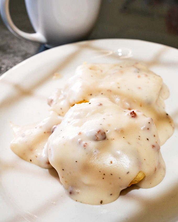 Behold the star attraction: biscuits drowning in a peppery sausage gravy that could make a vegetarian question their life choices. This is breakfast nirvana on a plain white plate.