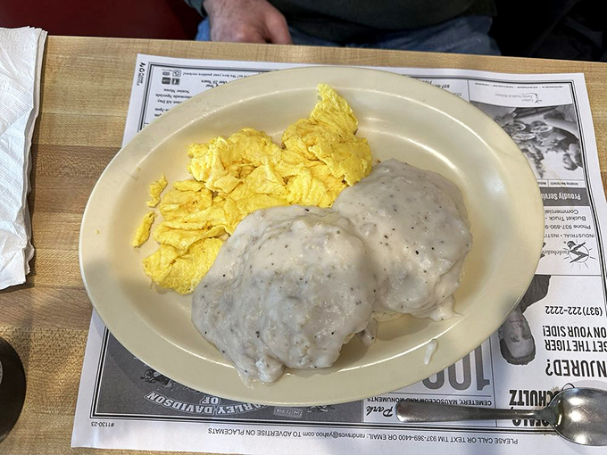 Behold the holy grail of breakfast: George's biscuits and gravy alongside fluffy scrambled eggs—a plate that's changed more lives than self-help books.