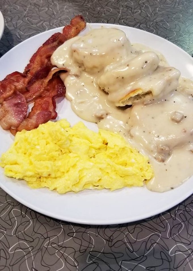 Biscuits drowning happily in creamy sausage gravy, with perfectly scrambled eggs and crispy bacon standing by. Breakfast nirvana achieved.