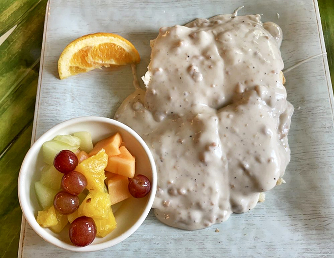 Biscuits swimming in creamy gravy alongside fresh fruit&mdash;proof that indulgence and virtue can peacefully coexist on the same plate.