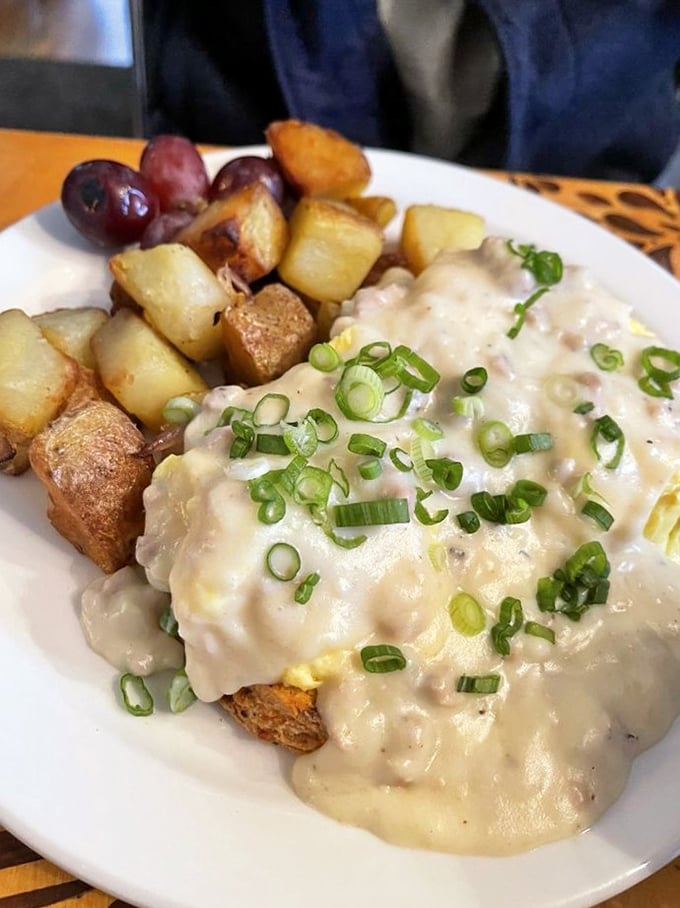 Behold the holy grail of comfort food! Creamy sausage gravy cascades over golden biscuits, with crispy potatoes standing by for the inevitable plate-cleaning.