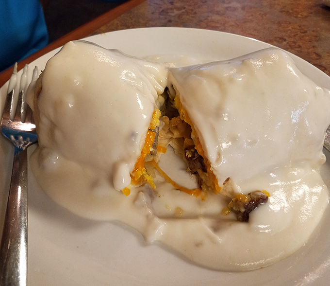 Behold the breakfast burrito in its natural habitat—swimming in country gravy like Michael Phelps in an Olympic pool of deliciousness.