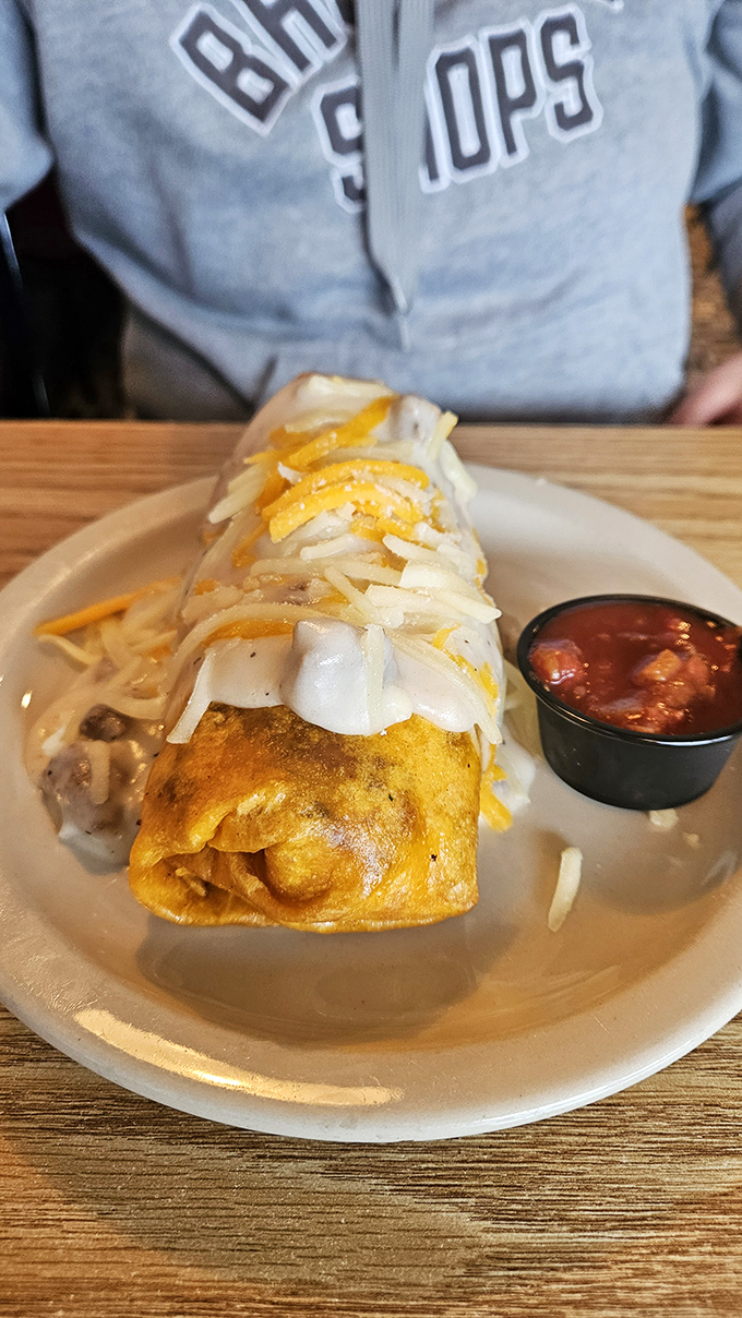 Behold the breakfast burrito in all its cheese-crowned glory! This tortilla-wrapped masterpiece comes with salsa that kicks your taste buds awake.