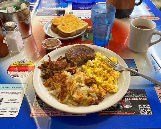 Breakfast perfection on a plate: crispy hashbrowns, scrambled eggs that actually taste like eggs, and a hamburger steak that means business.