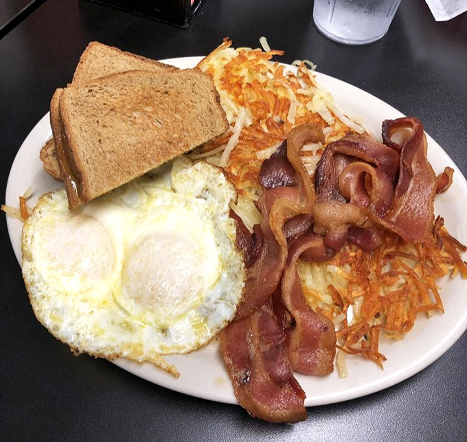 Breakfast perfection on a plate: crispy hash browns, perfectly cooked eggs, and bacon that makes you question all other bacon.