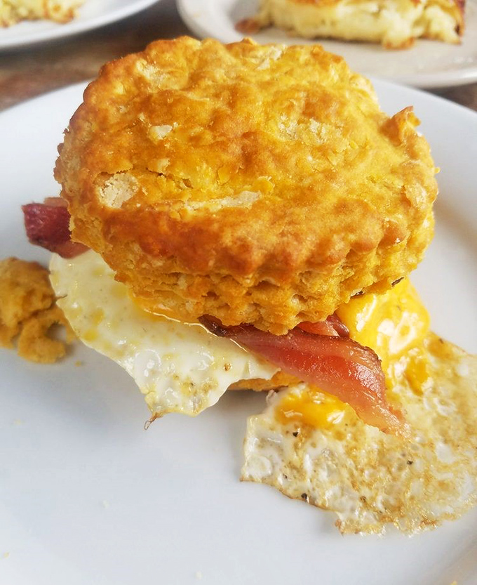 The holy trinity of breakfast: golden sweet potato biscuit, perfectly runny egg, and bacon that would make even vegetarians reconsider their life choices.