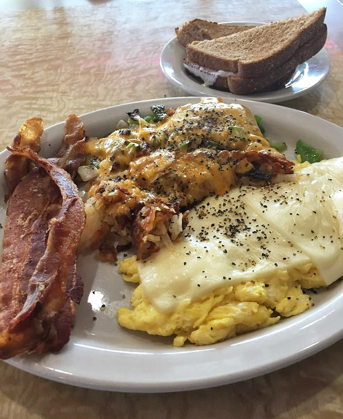 Cheese melting over perfectly scrambled eggs alongside crispy bacon. This plate doesn't need Instagram filters&mdash;it's already food perfection.
