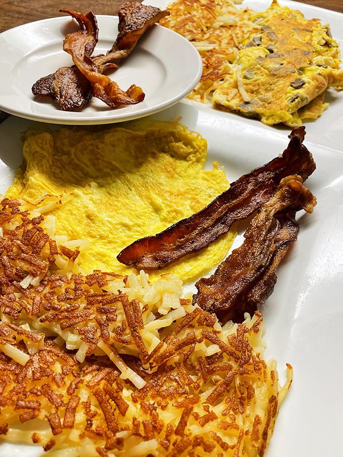 Golden hash browns with that perfect crisp-to-soft ratio share the plate with eggs and bacon that would make even diet-conscious diners temporarily abandon their principles.