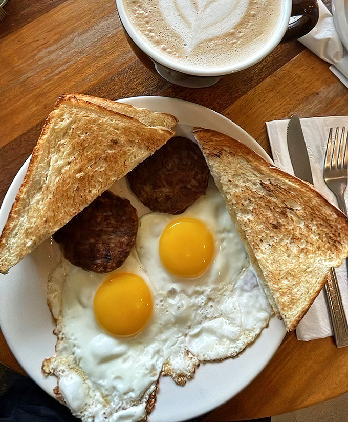 Sunny-side perfection on a plate! These golden-yolked eggs with sausage patties and toast are breakfast's greatest hits album.