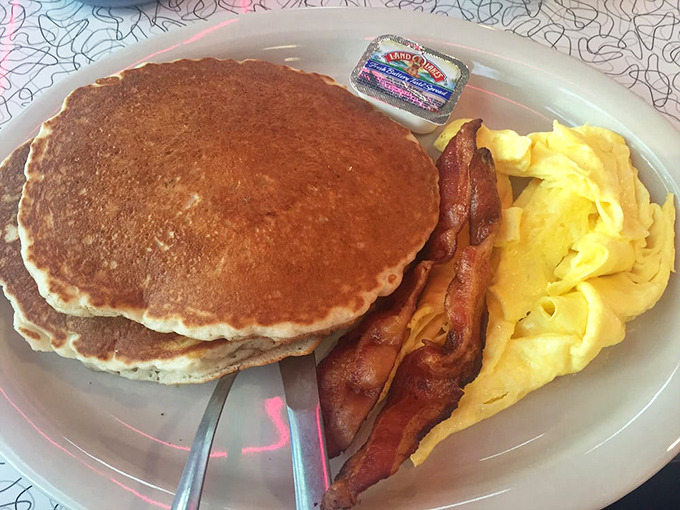 Pancakes so perfectly golden they'd win medals at the Olympics, with eggs and bacon playing essential supporting roles in this breakfast blockbuster.