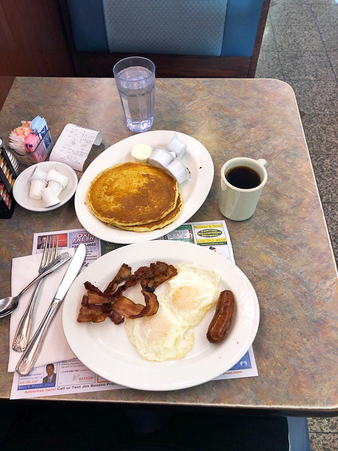 Breakfast perfection on a plate: golden pancakes, crispy bacon, and eggs that make you wonder why you ever attempted cooking them at home.