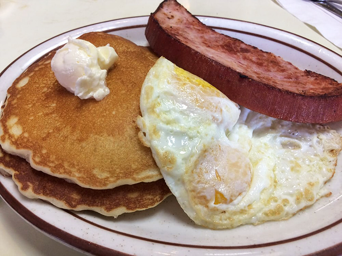 Breakfast trinity: golden pancakes, perfectly sunny eggs, and ham steak that doesn't need Instagram filters to look mouthwatering. This is food that satisfies the soul.