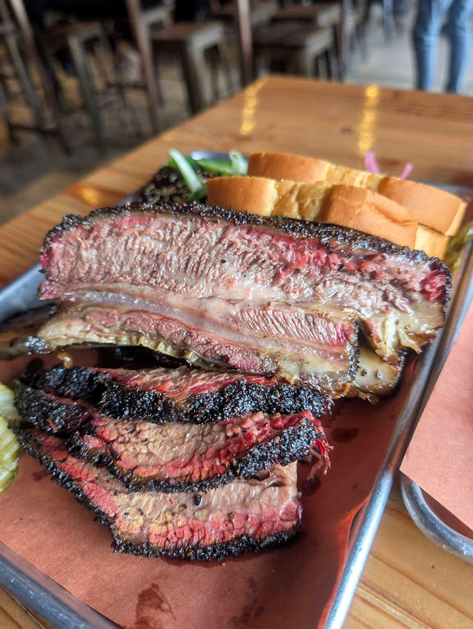 Behold the holy grail of Texas-style brisket: a bark so perfect it should be in a museum, with that telltale pink smoke ring that brings grown adults to tears.
