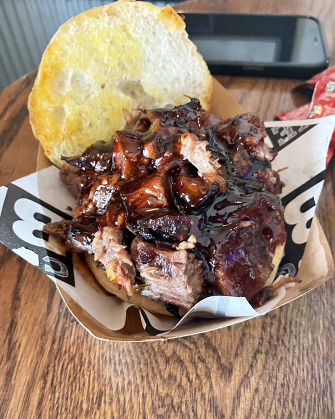 Behold the pinnacle of sandwich architecture: glistening, saucy chopped brisket nestled on a pillow-soft bun that's witnessed barbecue nirvana.
